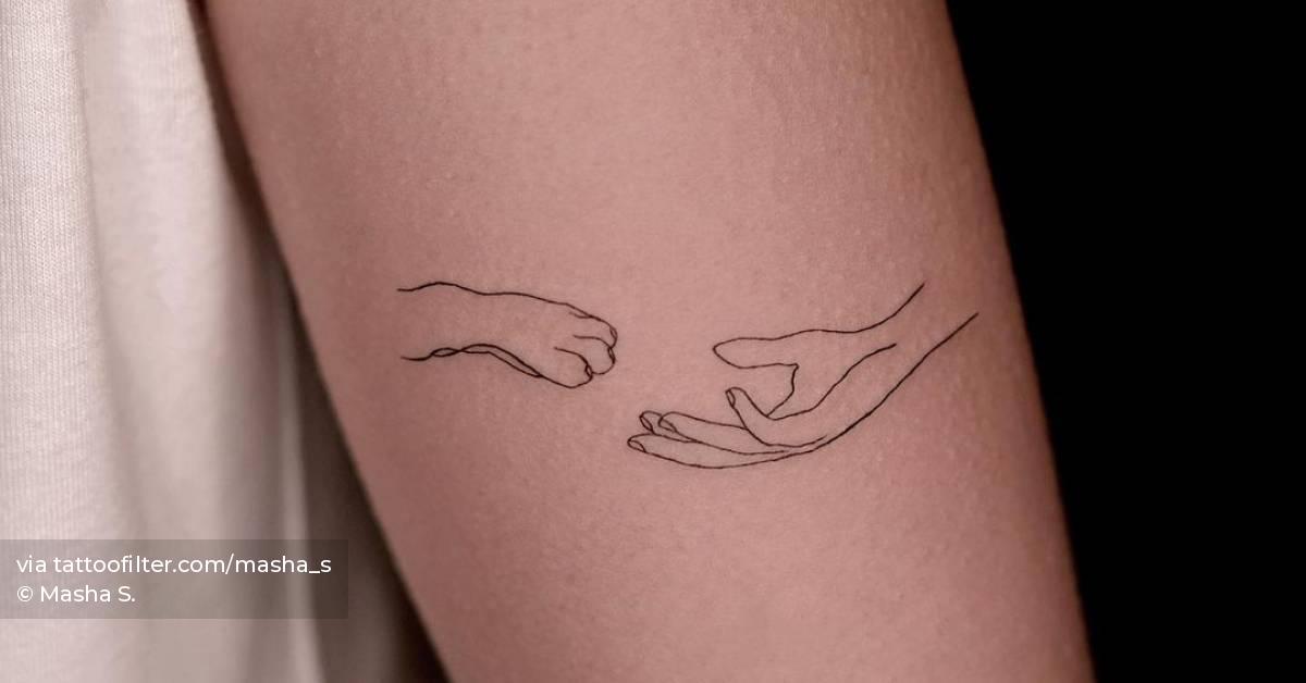 Fine line hand and paw tattoo done on the tricep,