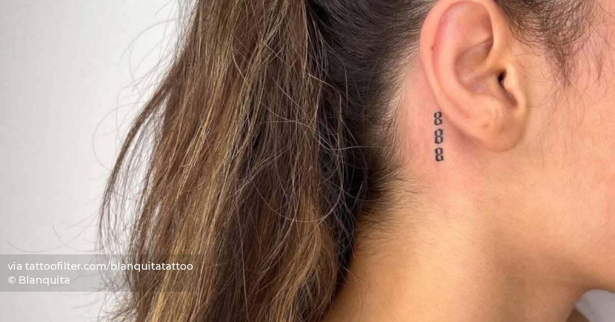 "888" lettering tattoo located behind the ear.
