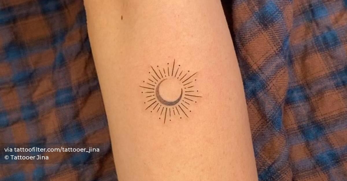 Fine line sun and moon tattoo on the forearm.