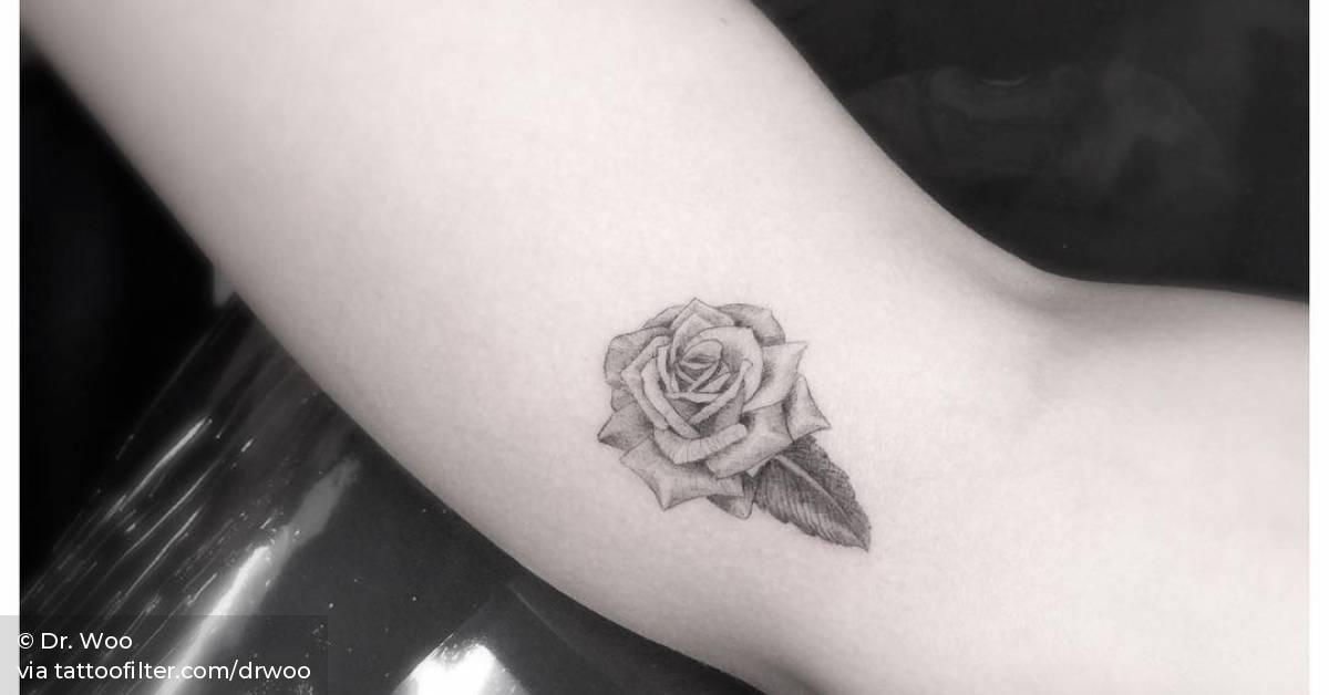Small fine line style rose tattoo on the right forearm.