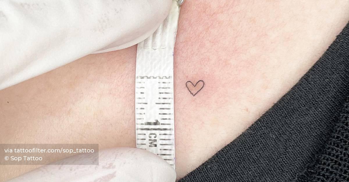 Micro heart tattoo located on the chest, minimalistic