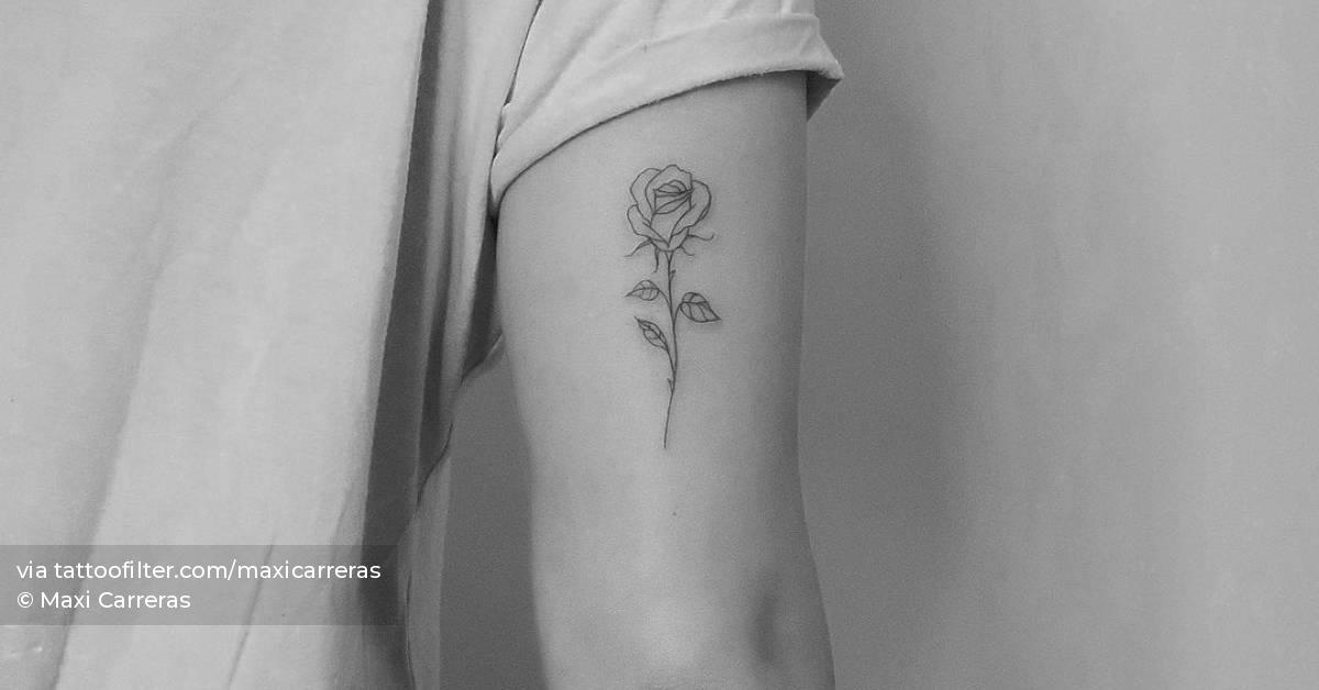 Fine line rose tattoo on the tricep.
