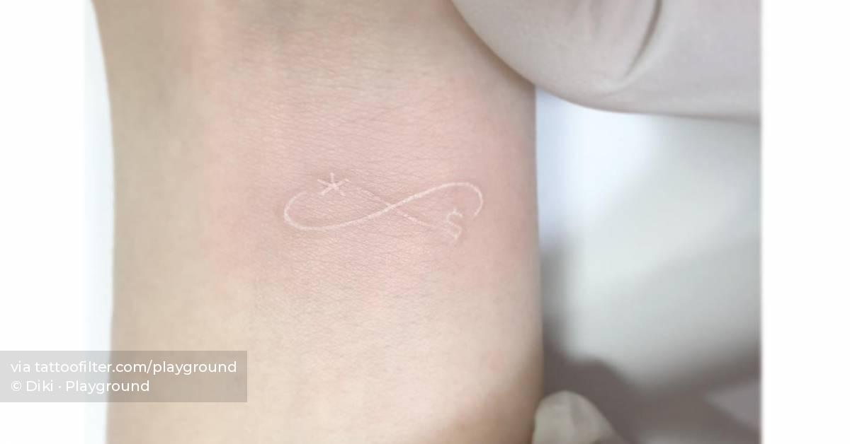 Infinity symbol tattoo done in white ink, located on