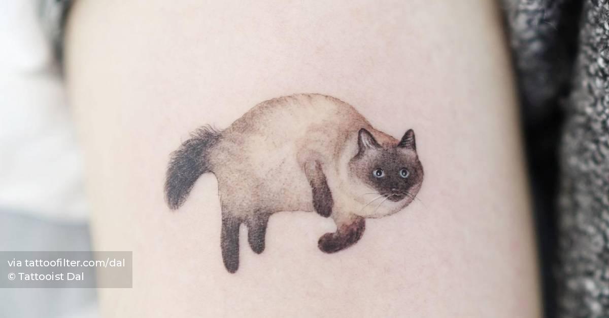 Siamese cat tattoo placed on the upper arm.