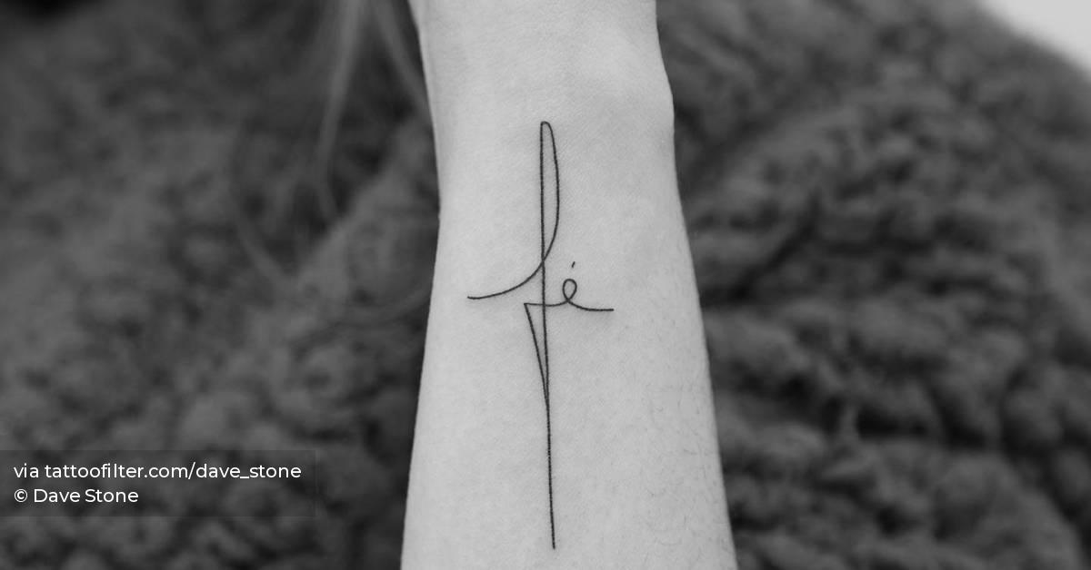 "Fé" lettering tattoo located on the wrist.