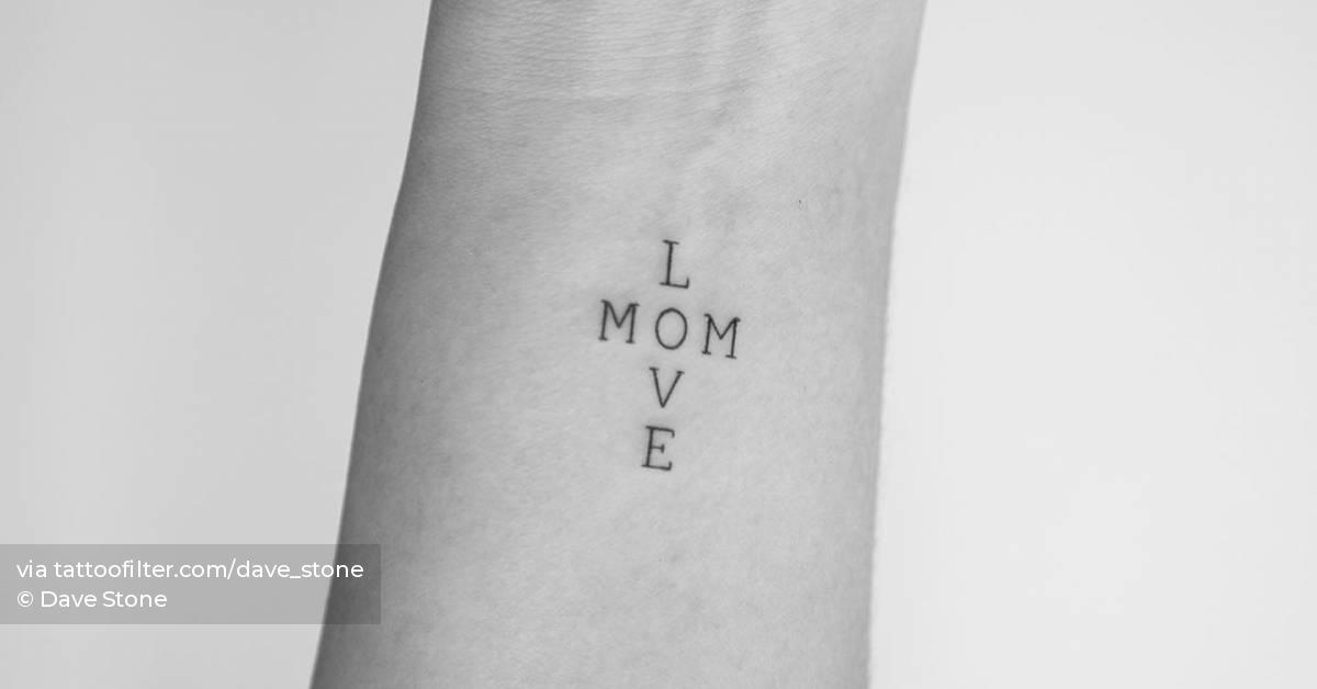 "Mom Love" lettering tattoo located on the wrist.