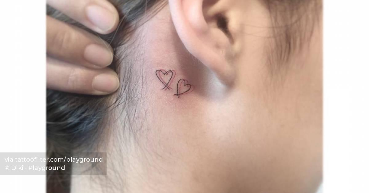 Minimalistic hearts tattooed behind the ear.