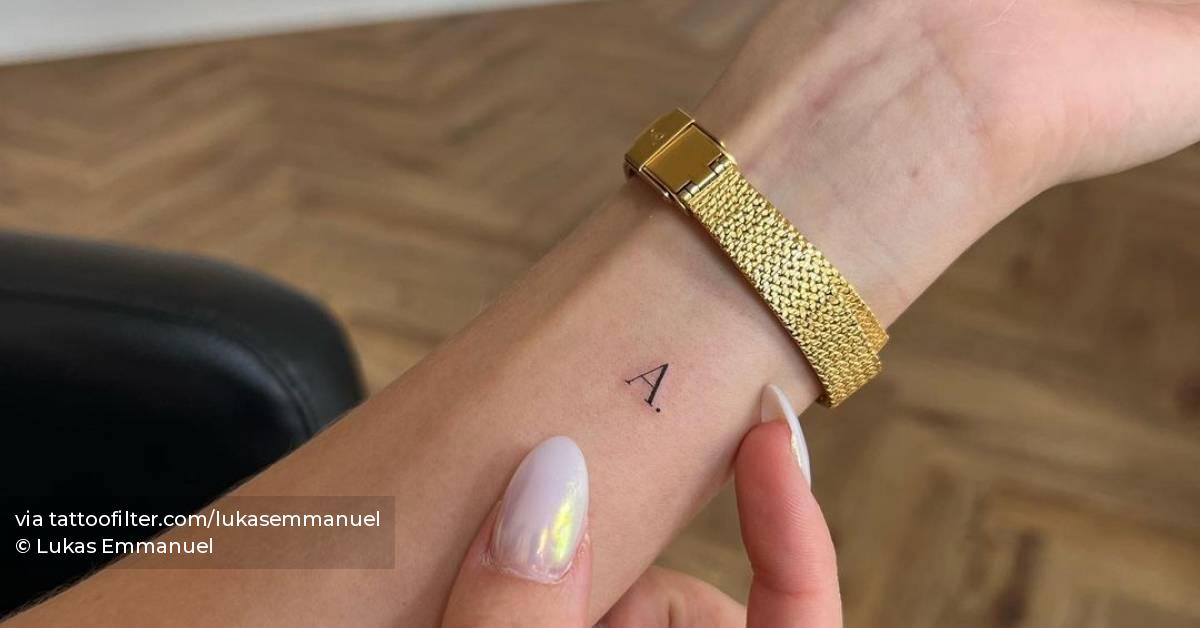 Tiny letter "A" tattoo located on the wrist,