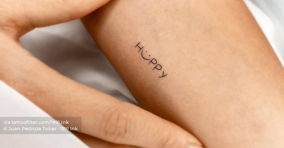 Tattoo of the word "happy" with a little smiley face.