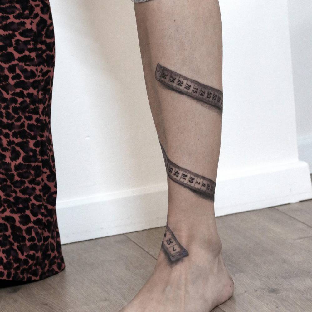 Black And Grey Tape Measure Tattoo Located On The Shin Black And Grey Tape Measure Tattoo Located On The Shin