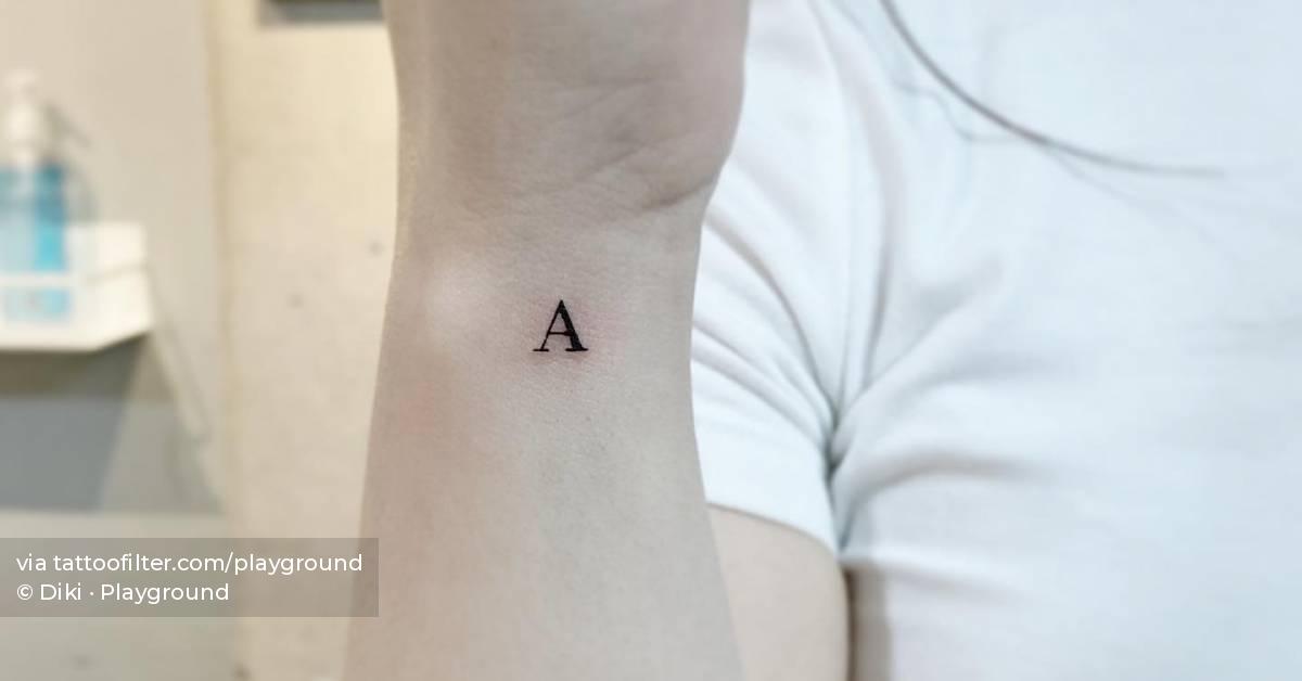 Minimalistic letter "A" tattoo located on the wrist.