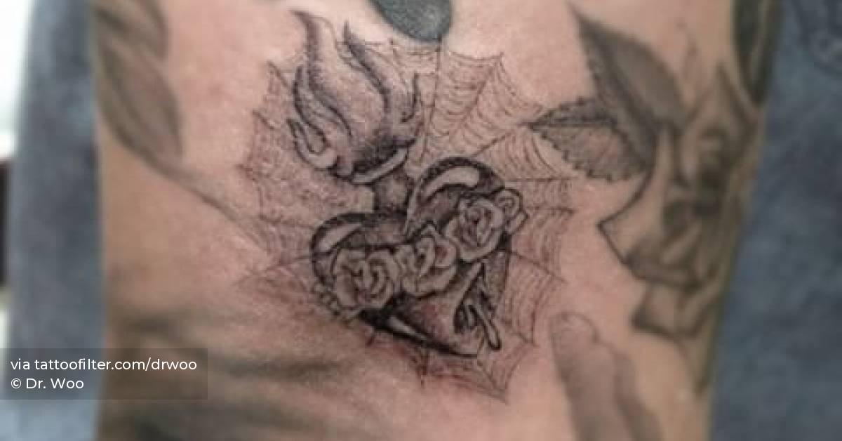 Little flaming heart tattoo located on the upper arm.