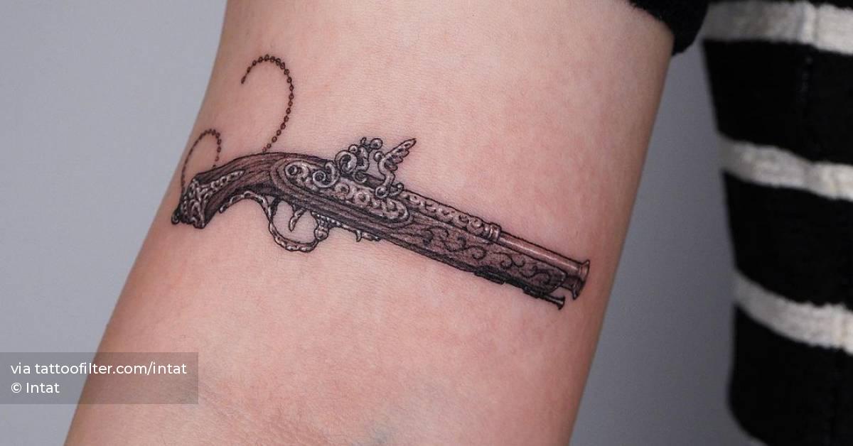 Micro-realistic gun tattoo located on the bicep.
