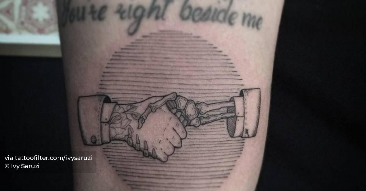 Handshake tattoo located on the upper arm.