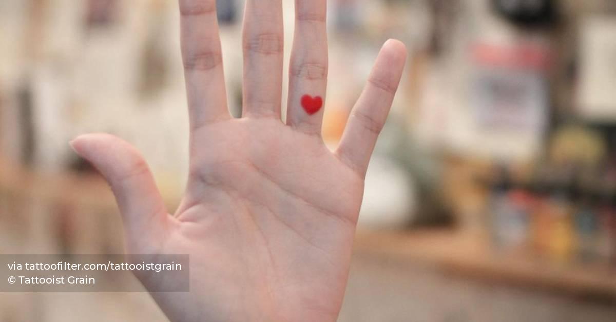 Tiny red heart tattoo located on the finger,