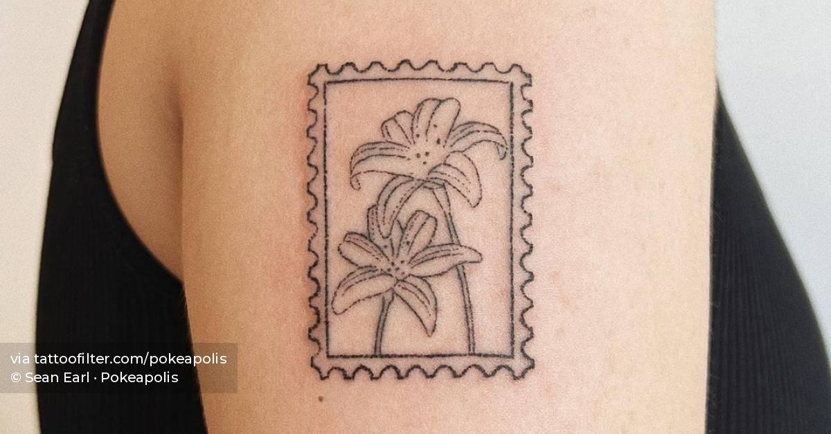 Hand poked lily stamp tattoo located on the upper arm.