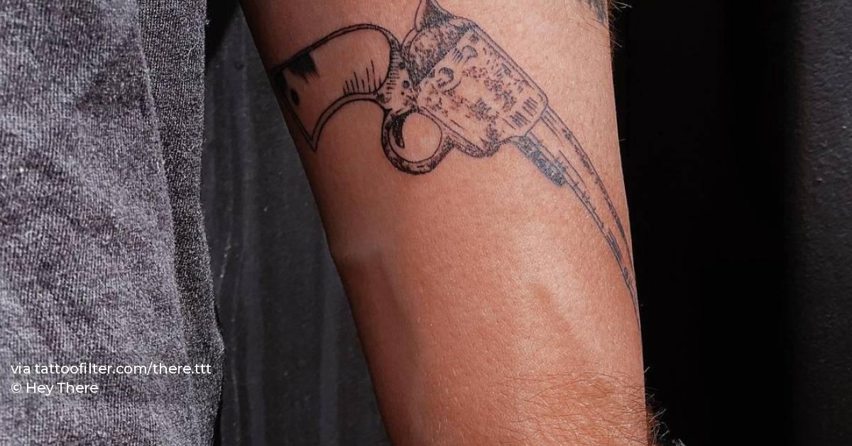 Revolver tattoo located on the forearm.