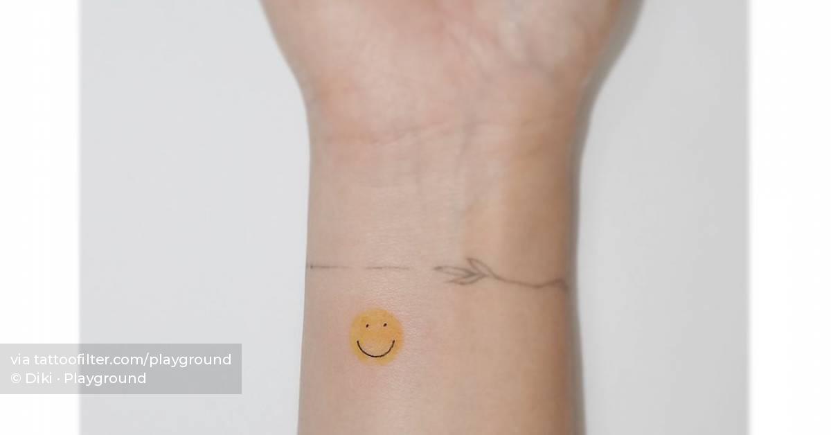 Minimalistic style smiley face tattoo located on the