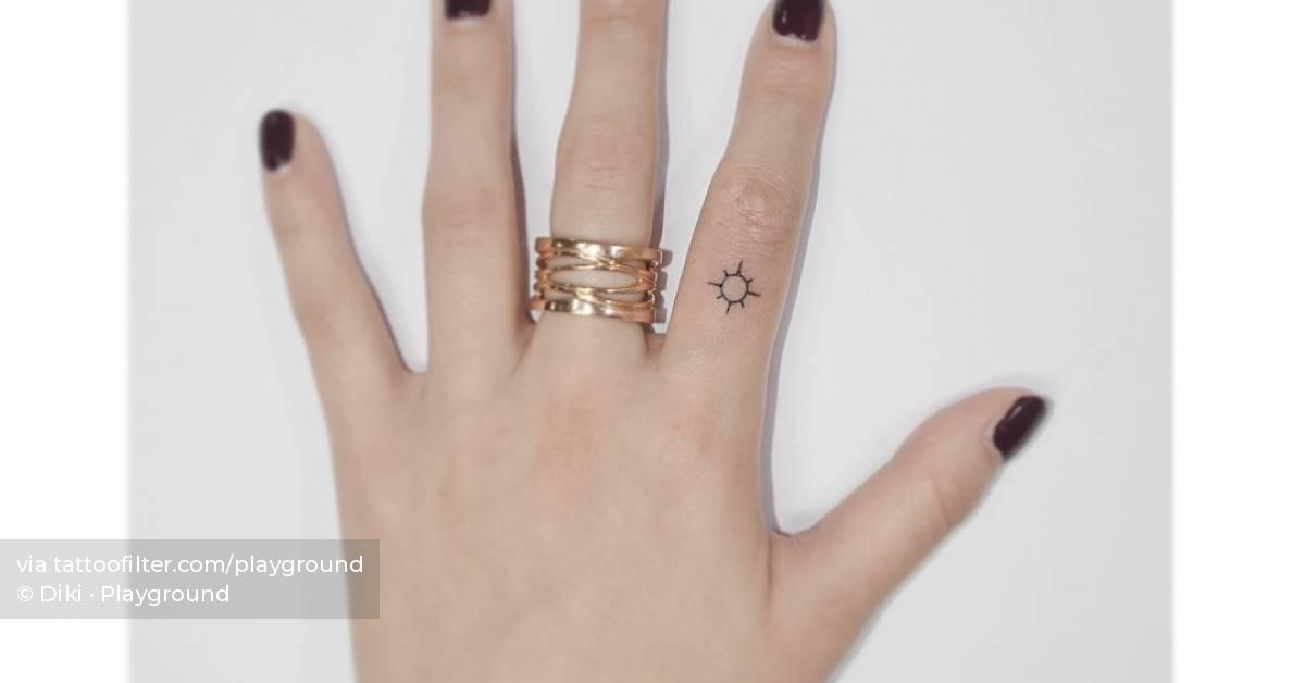 Tiny minimalistic sun tattoo done on the finger.