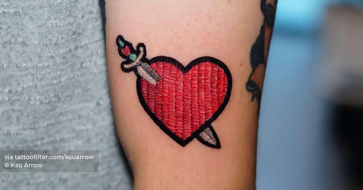 Embroidery style heart and dagger patch tattoo located