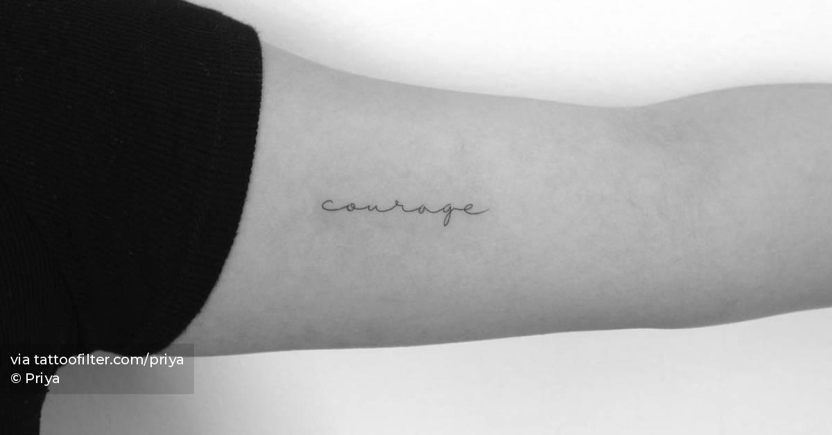 Tattoo of the word "courage" handwritten on the inner