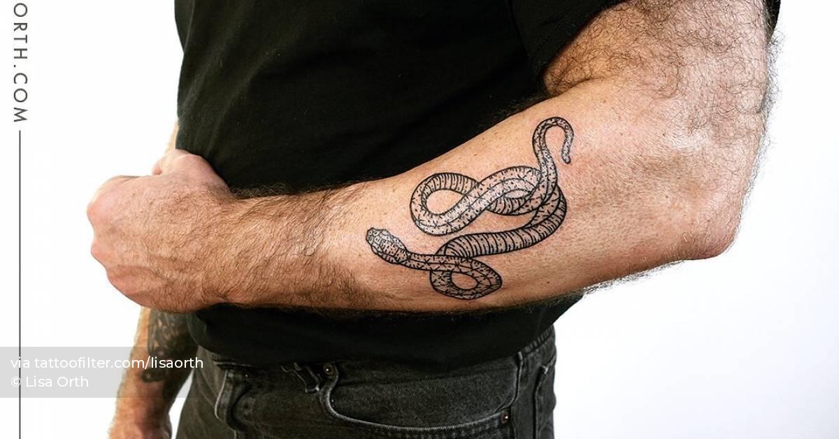 Tattoo of a snake located on the forearm, engraving