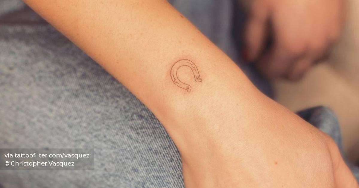 Fine line horseshoe tattoo located on the wrist.