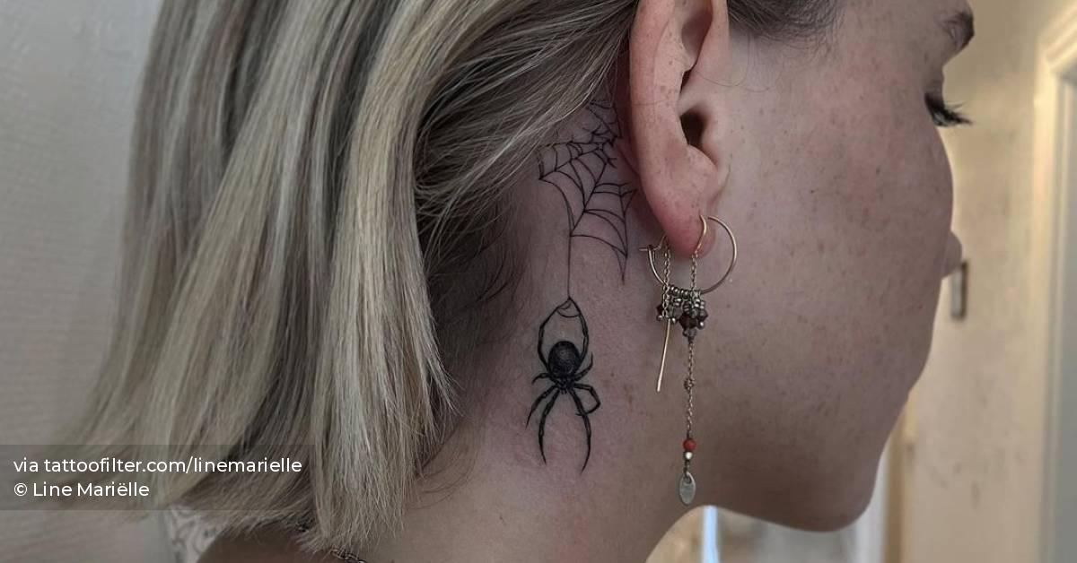 Itsy bitsy spider tattooed behind the ear.