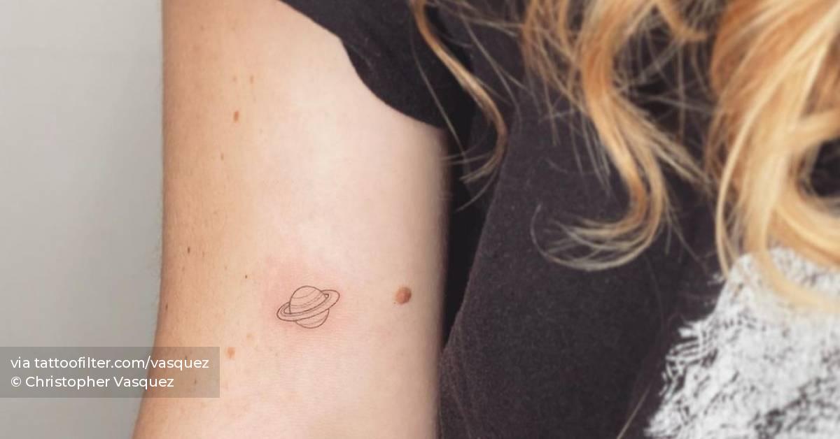 Tiny fine line Saturn tattoo located on the bicep.