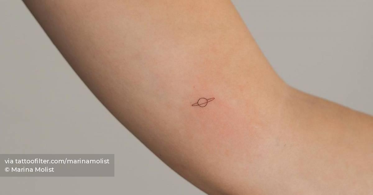 Tiny saturn tattoo located on the inner arm, fine line