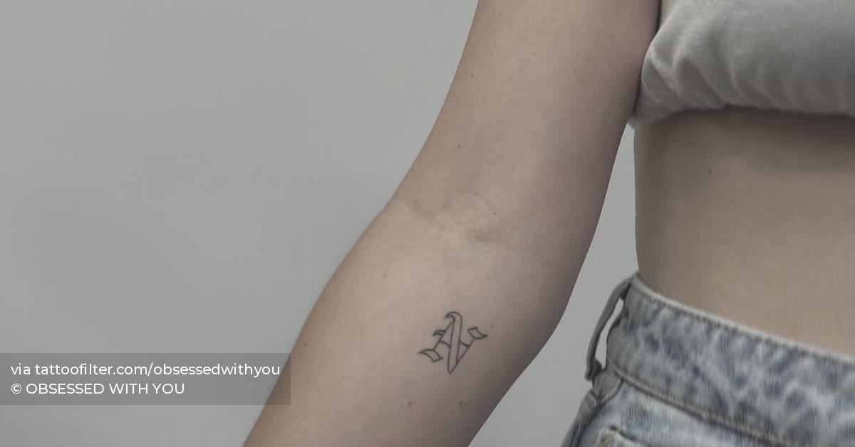 Healed letter "N" tattoo done on the inner forearm.