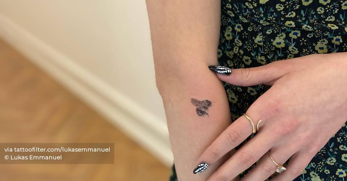 Bumblebee tattoo on the elbow, micro-realistic style.