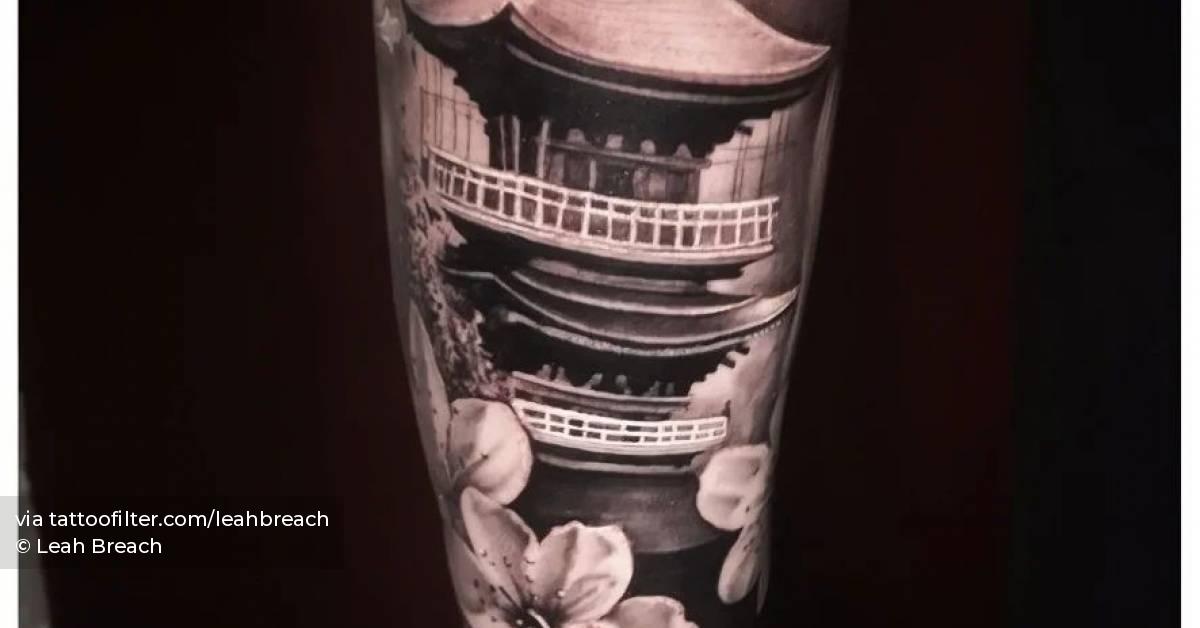 Pagoda and cherry blossoms tattoo located on the shin,