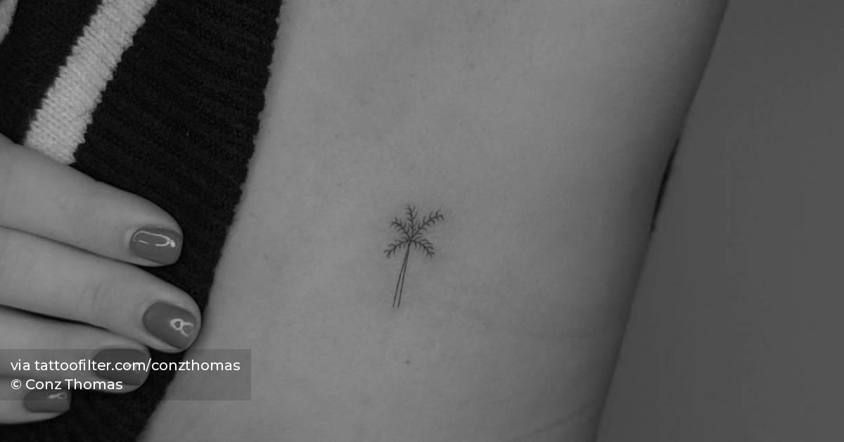 Tiny palm tree tattoo located on the side boob, fine