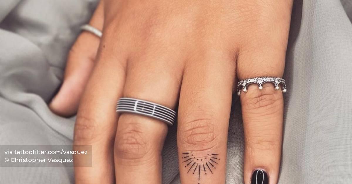 Fine line ornamental finger tattoo.