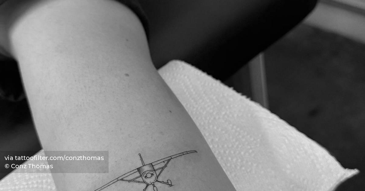Fine line plane tattoo located on the tricep.