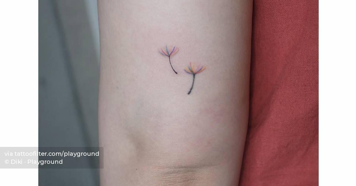 Minimalistic style dandelion seeds tattooed on the