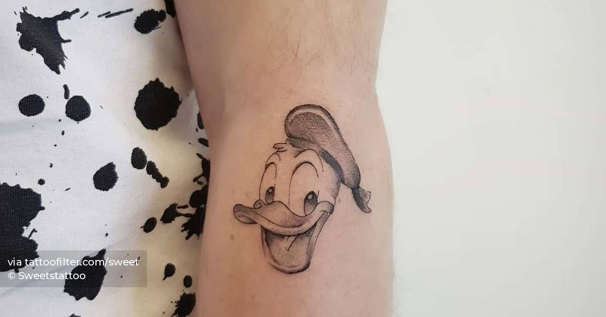 Donald Duck portrait tattoo located on the forearm.
