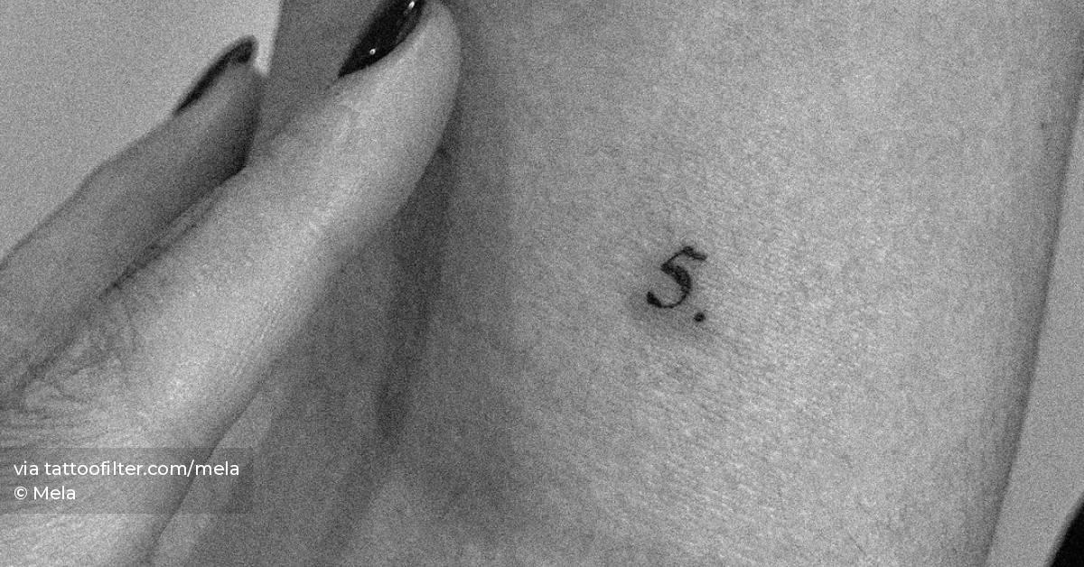 Minimalist number 5 tattoo on the inner arm.