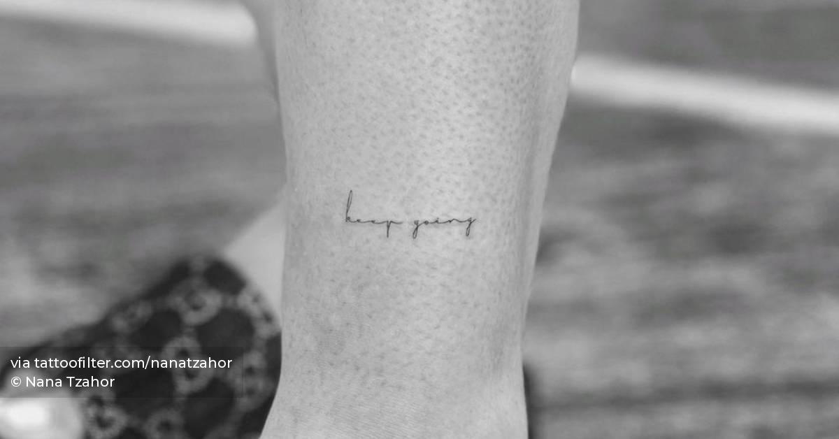"Keep going" lettering tattoo handwritten on the ankle.