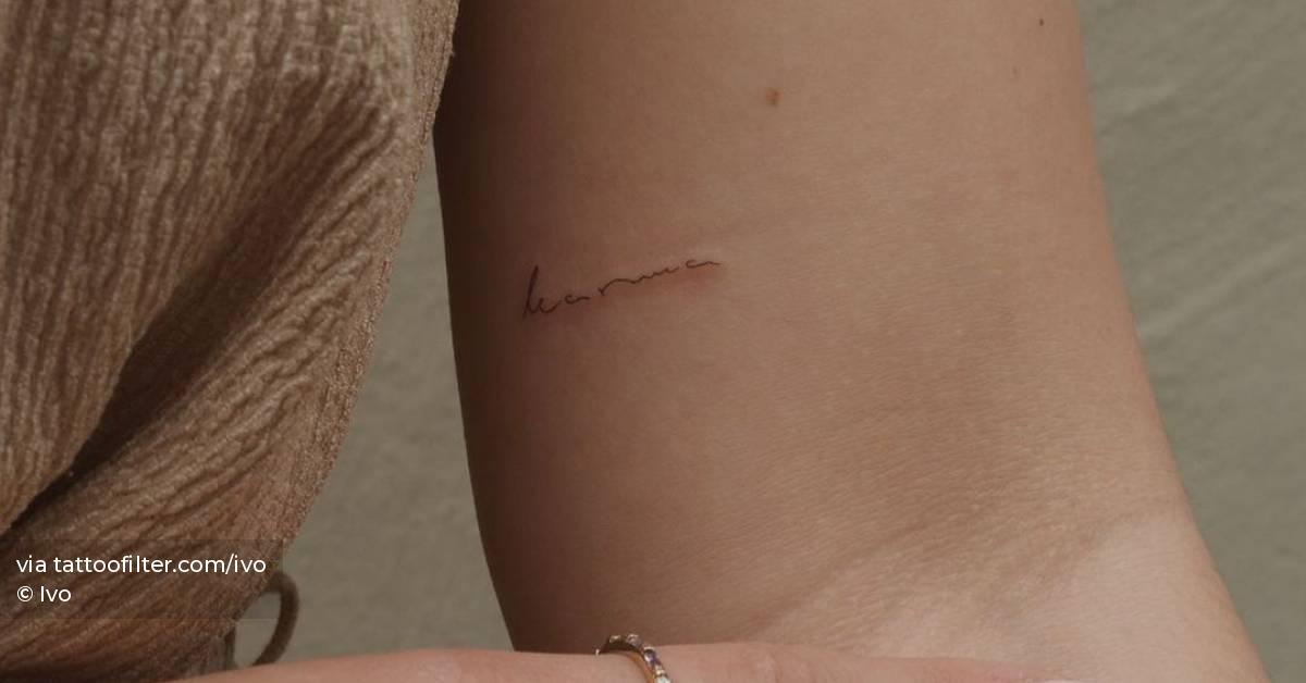 "Karma" lettering tattoo handwritten on the inner arm.