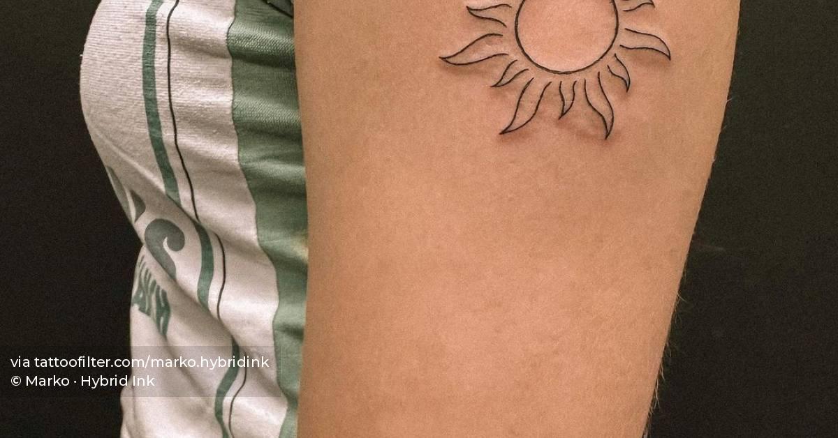 Fine line sun tattoo located on the upper arm.