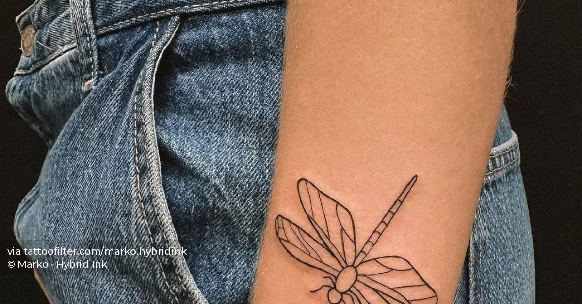 Fine line dragonfly tattoo located on the wrist.