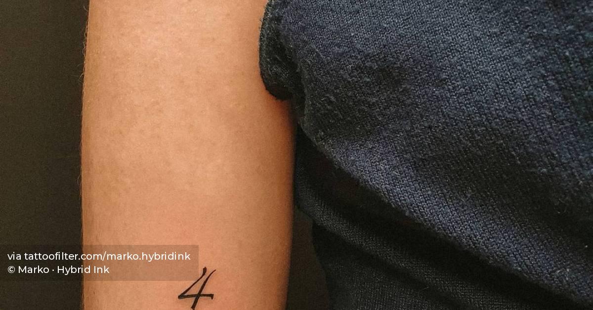 Number "4" tattoo placed on the upper arm.