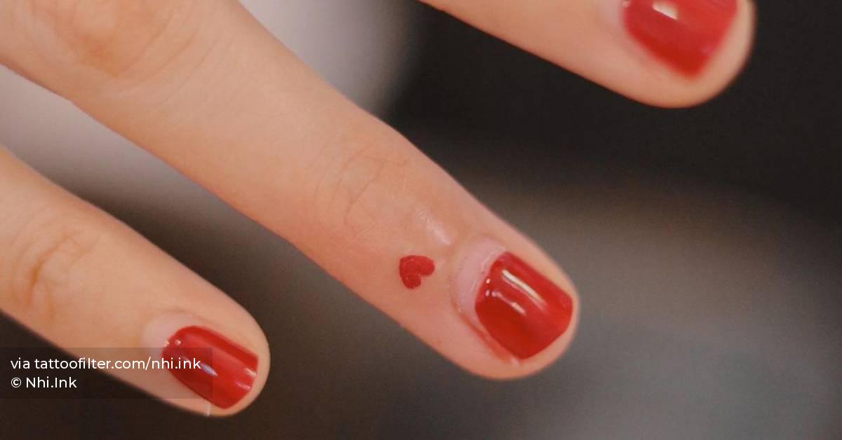 Micro red heart tattoo done on the finger, minimalistic