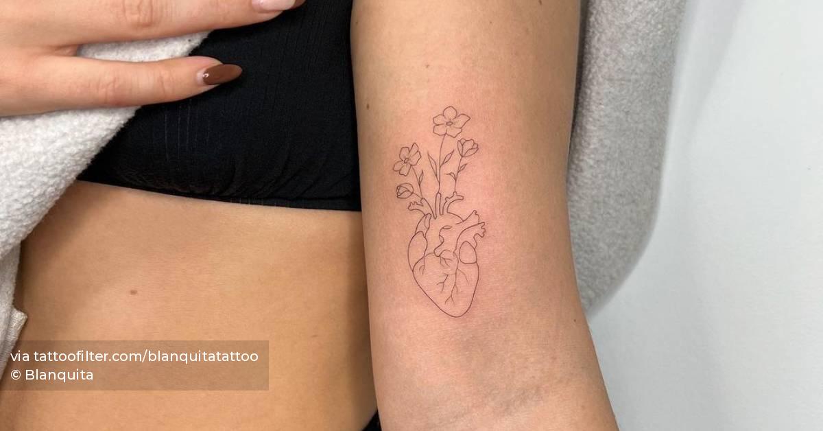 Fine line style anatomical heart and flowers tattoo