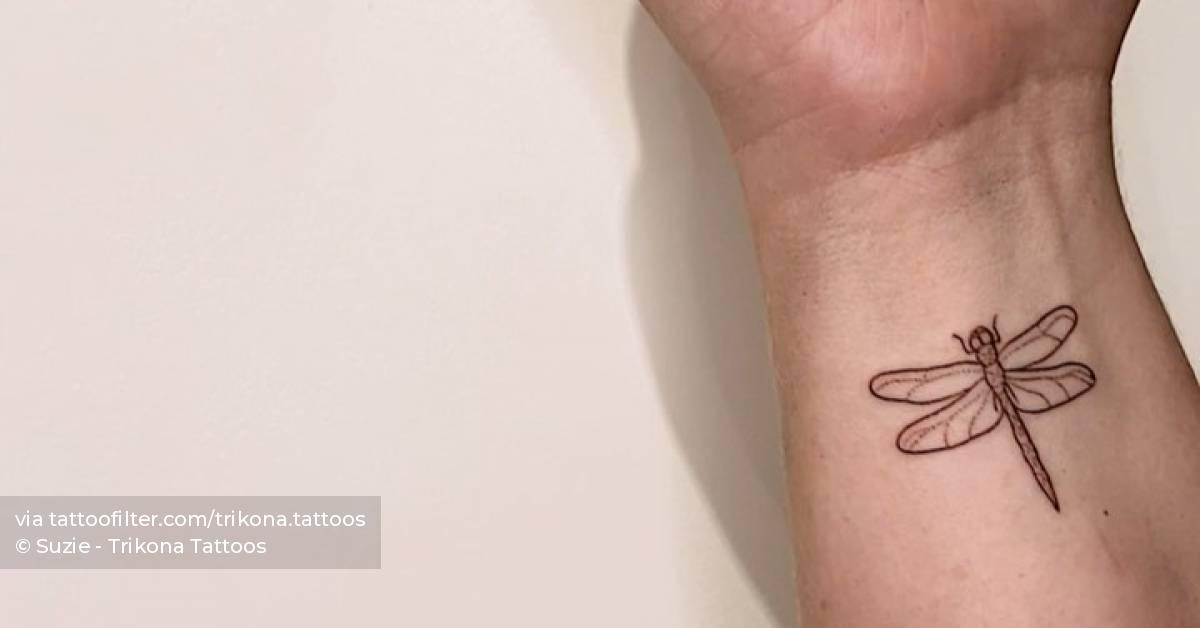 Hand poked dragonfly tattoo on the wrist.
