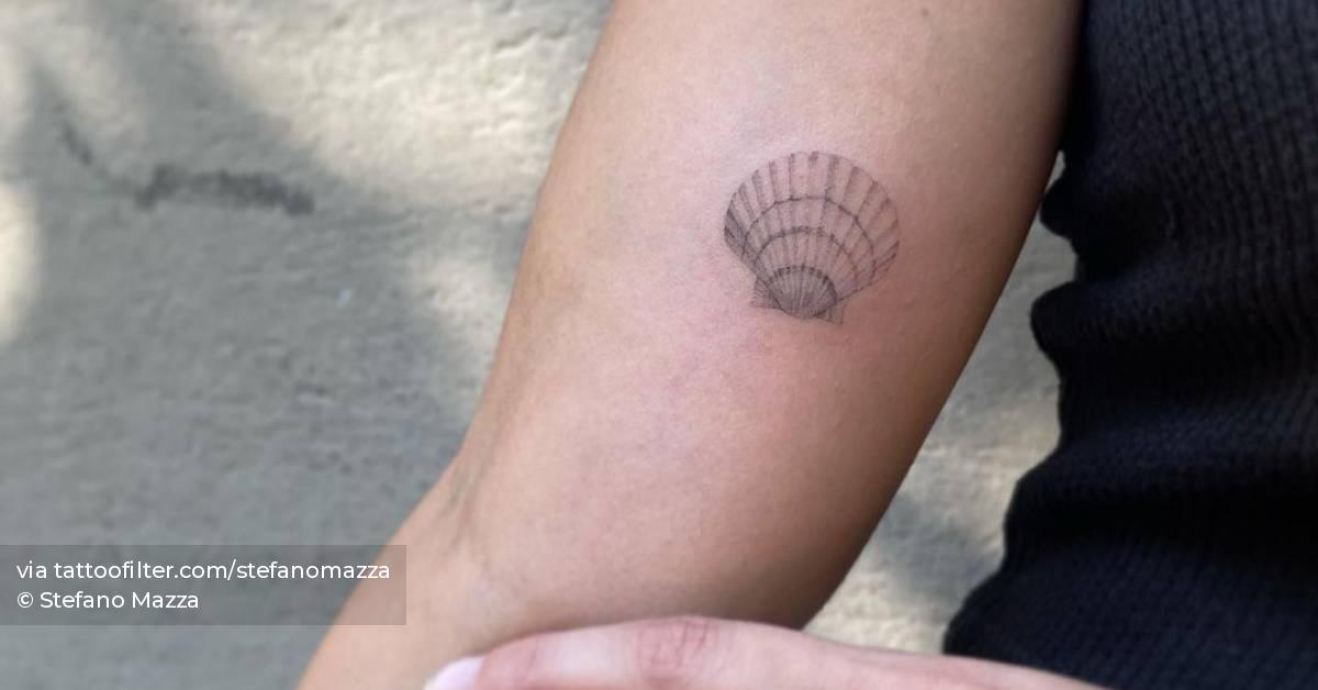 Micro-realistic shell tattoo on the inner arm.