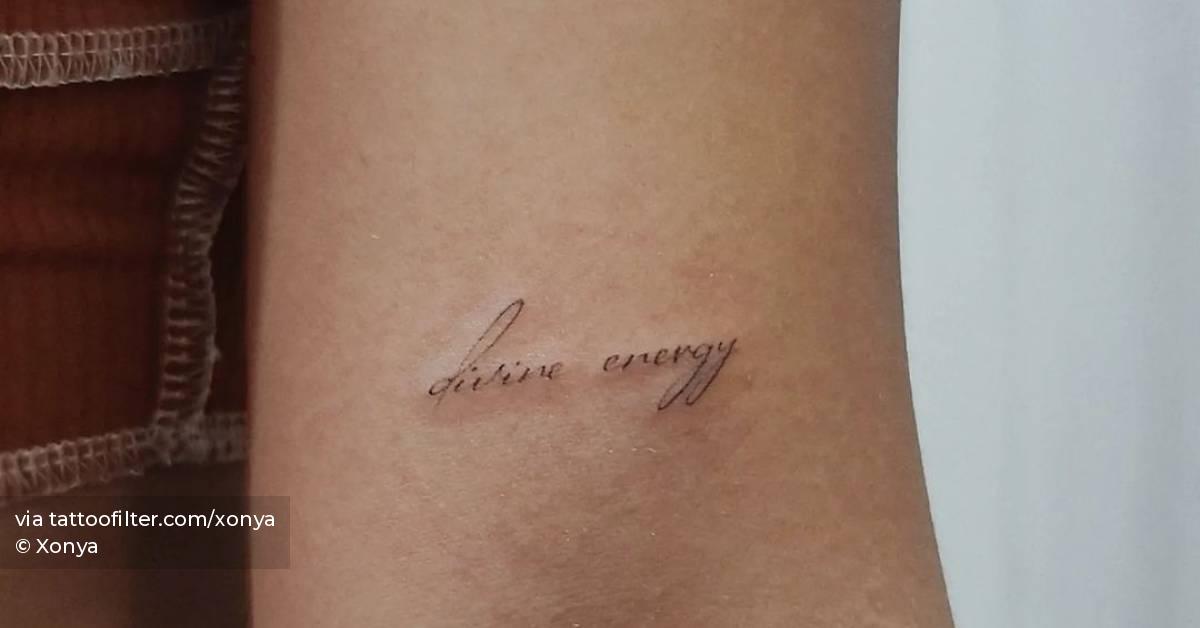 "Divine energy" lettering tattoo done on the bicep.