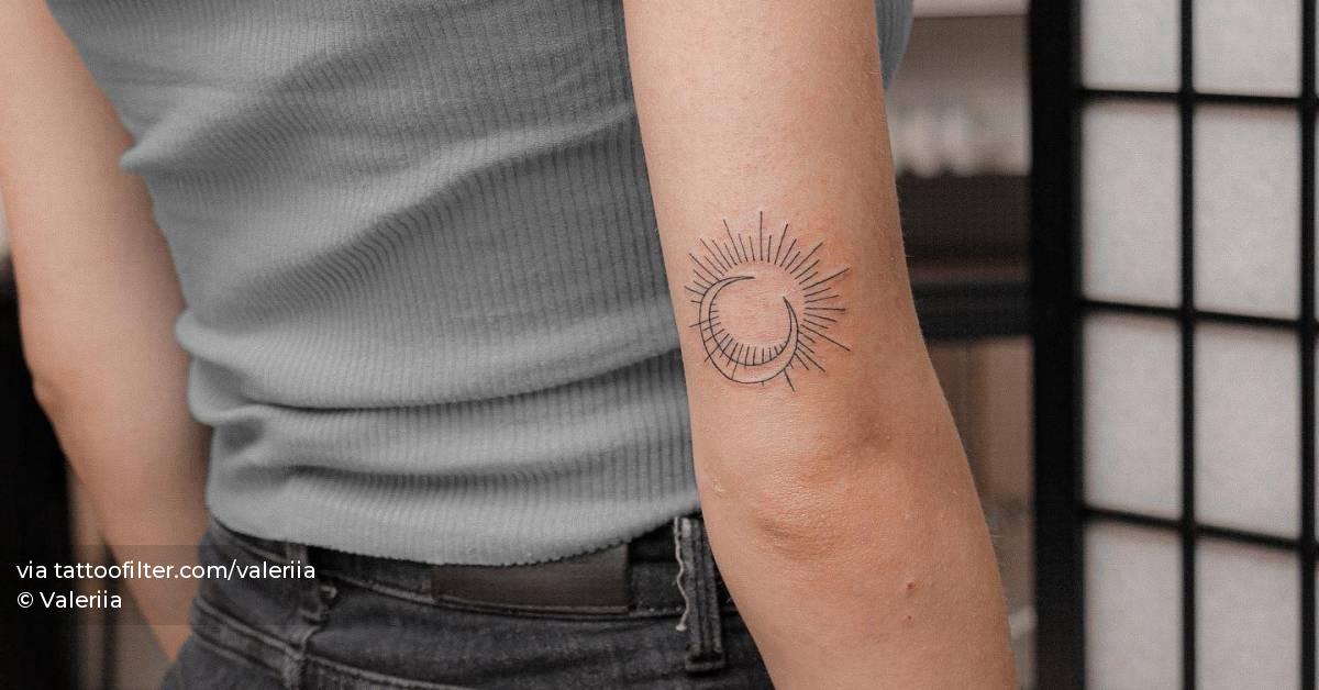 Fine line sun and moon tattoo located on the tricep.